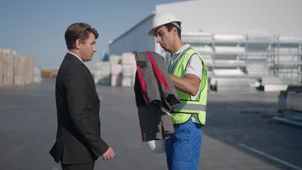 Side view of angry overwhelmed Middle Eastern man passing uniform to ...