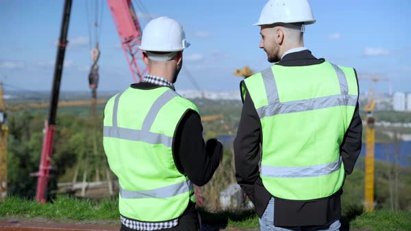 Back view portrait of two positive young men in uniform talking looking ...