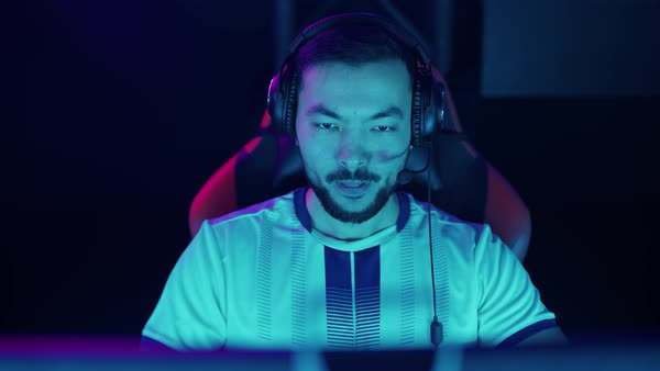 Portrait of a focused gamer, plays a video game, cyber sportsman at the ...