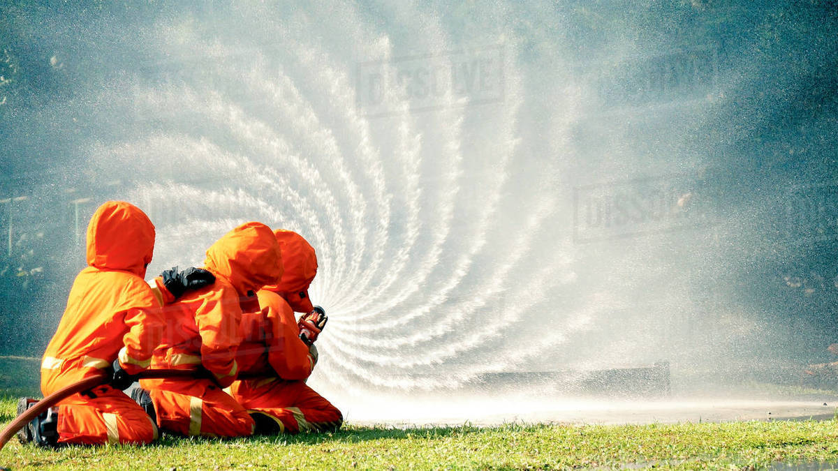 Firefighter fighting with flame using fire hose chemical water foam ...