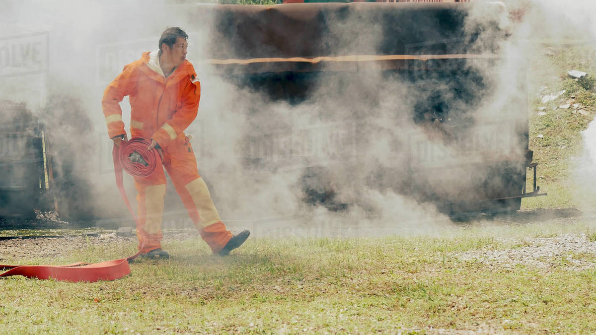 Firefighter fighting with flame using fire hose chemical water foam ...