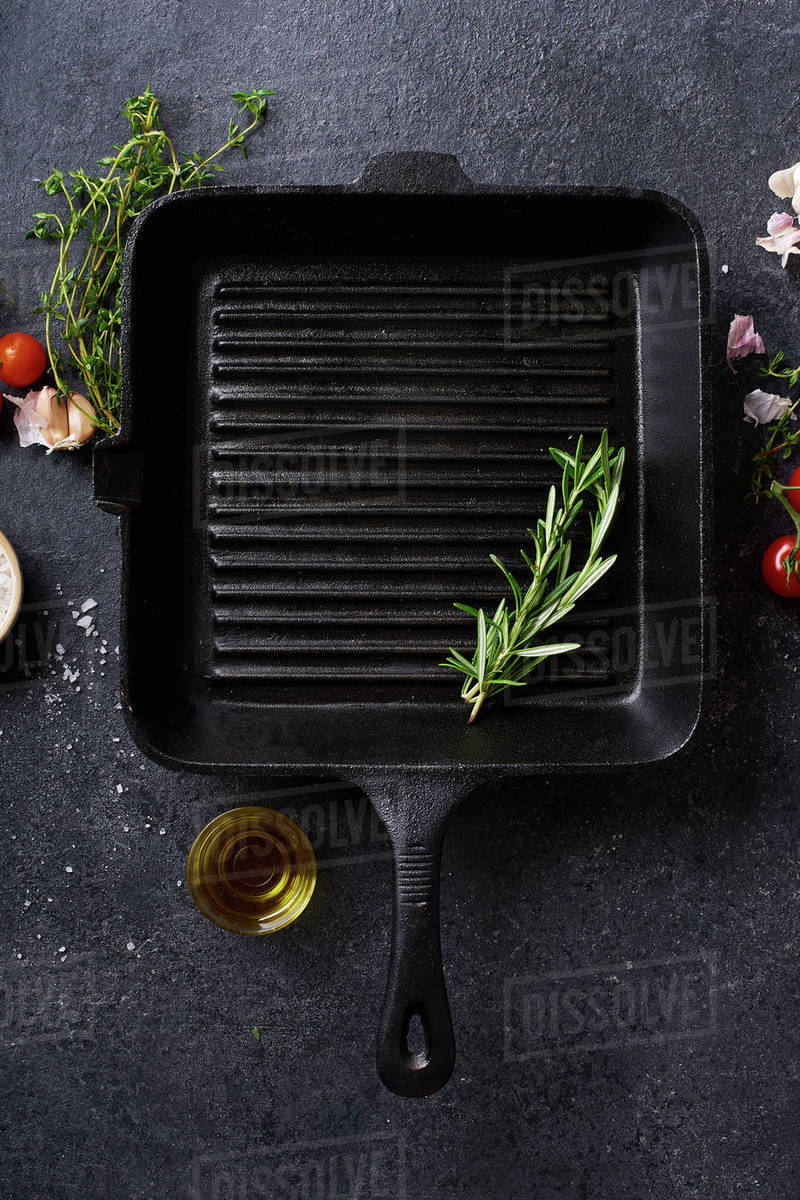 Flat lay top view black cast iron skillet for barbecue. Frying pan with ...