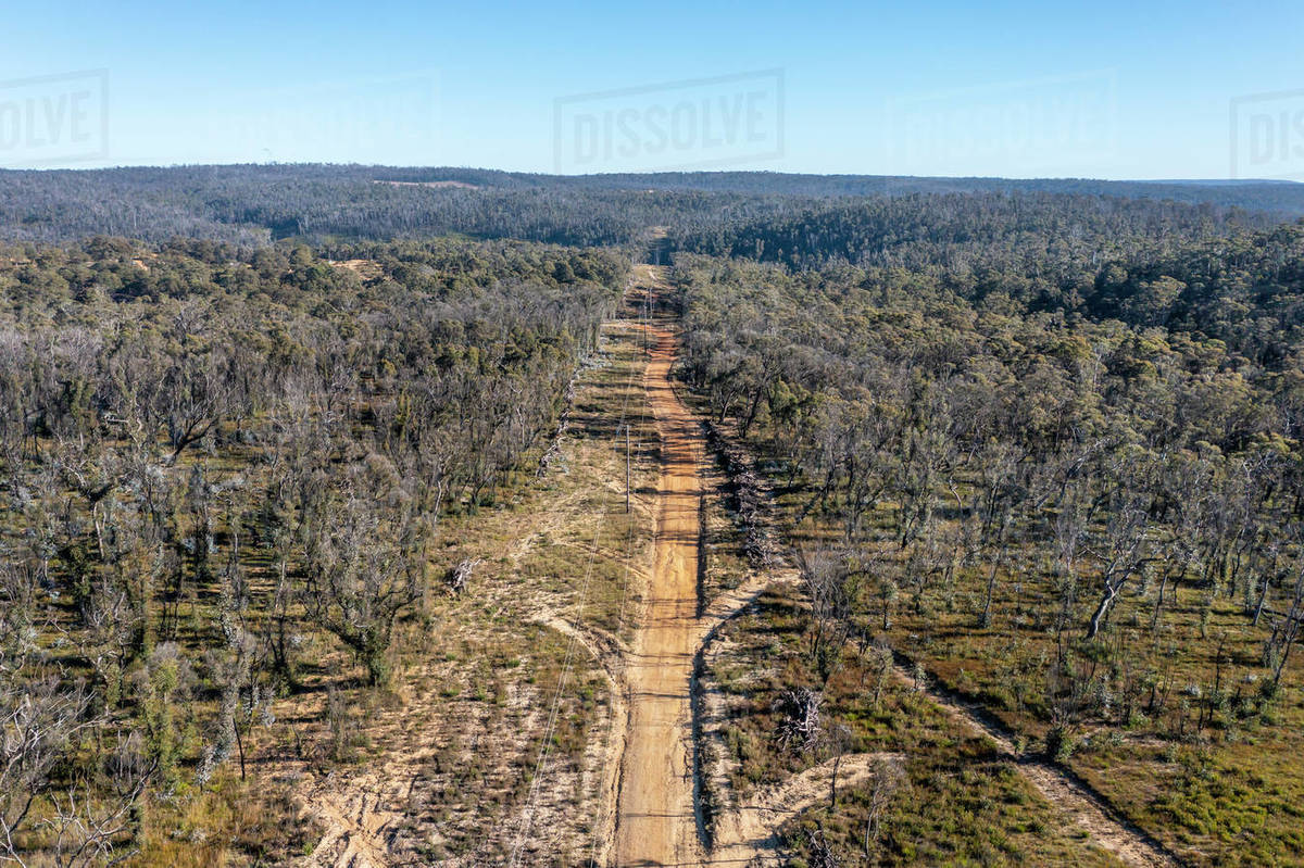 Drone aerial photograph of telephone poles and wires along a dirt track ...