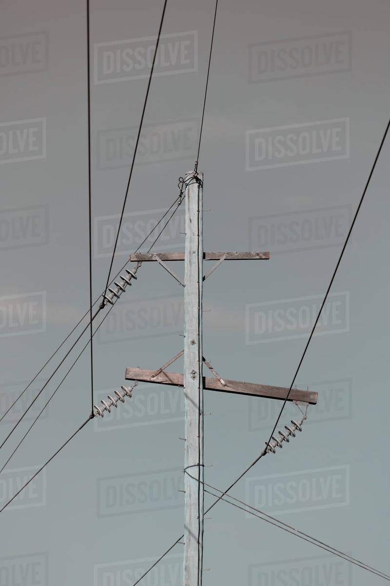 A wooden telephone post and cables against a blue sky - Stock Photo ...