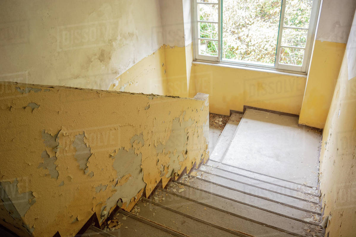 Old abandoned stairs in decay with yellow wall destroyed in old colony ...