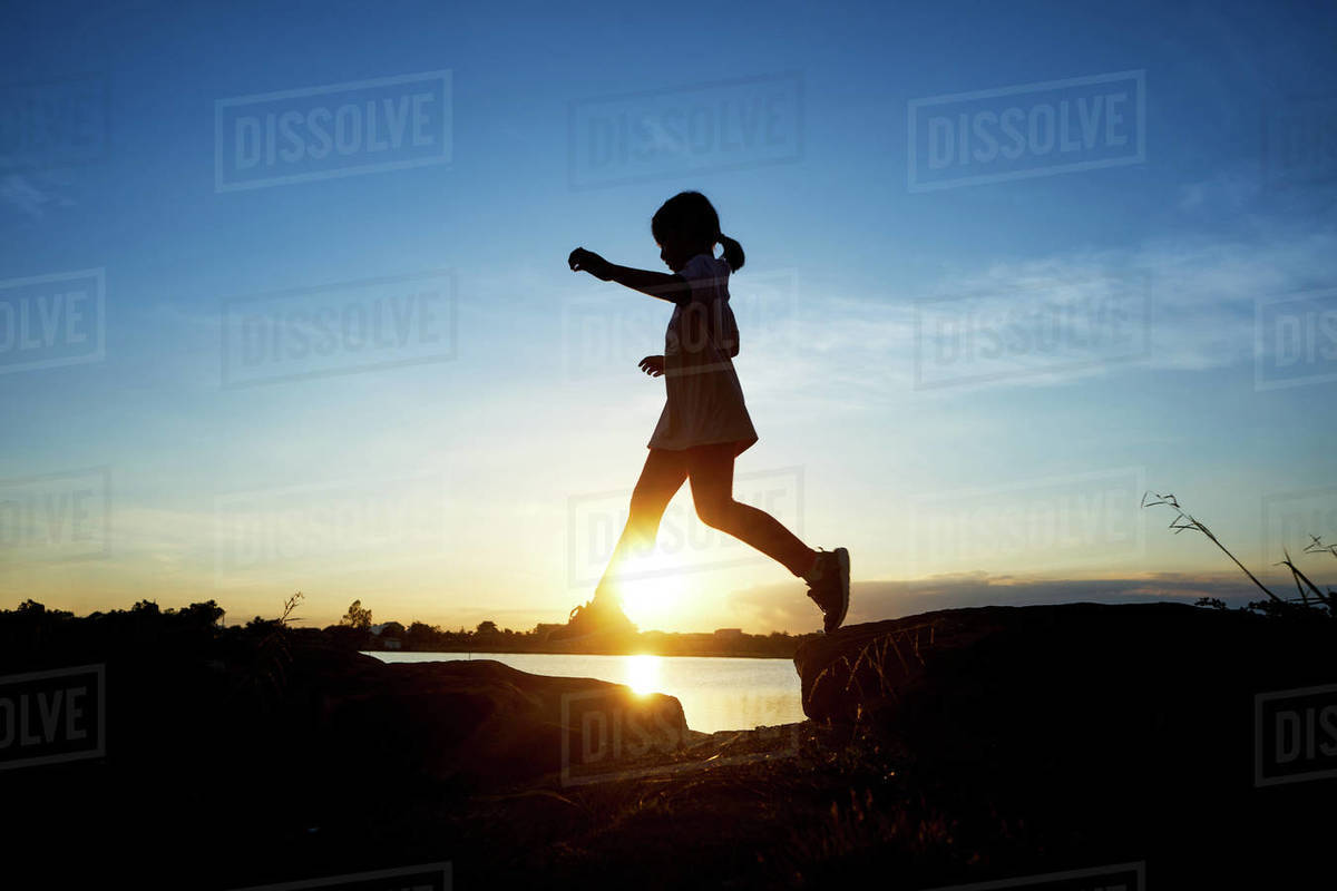 The silhouette of a girl jumping over a stone gap - Royalty-free Stock ...
