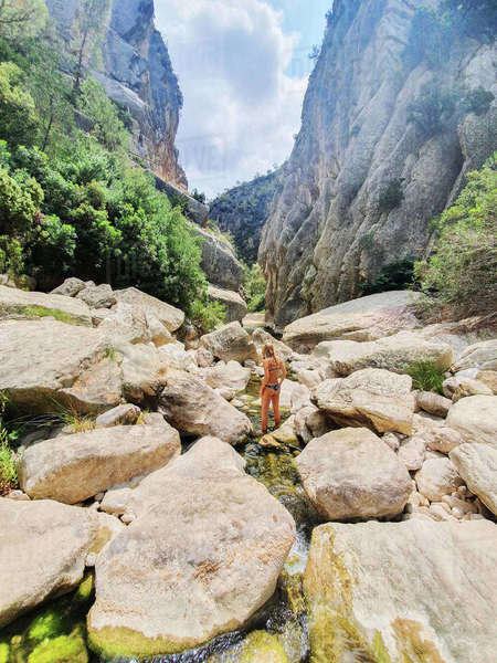 Woman wearing a bikini standing on the rocks in the valley with Clear ...