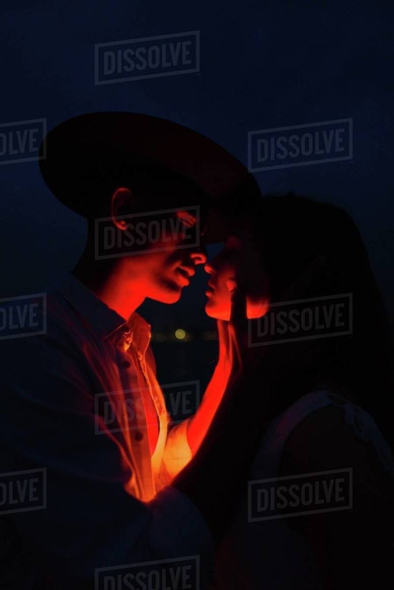 Couple hugging in the dark with neon light - Stock Photo - Dissolve