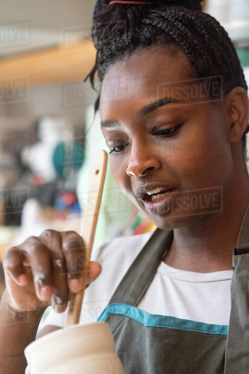Female ceramic artist glazing a cup - Stock Photo - Dissolve