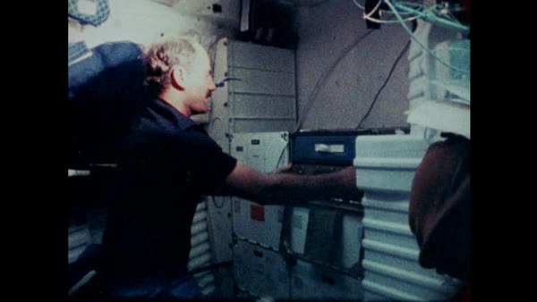 Astronaut James D. van Hoften, on board STS-41c extracts a student ...