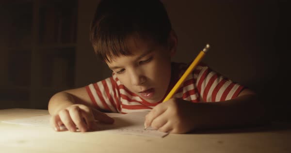 Young boy using pencil and writing. 5 year old boy learning to write ...