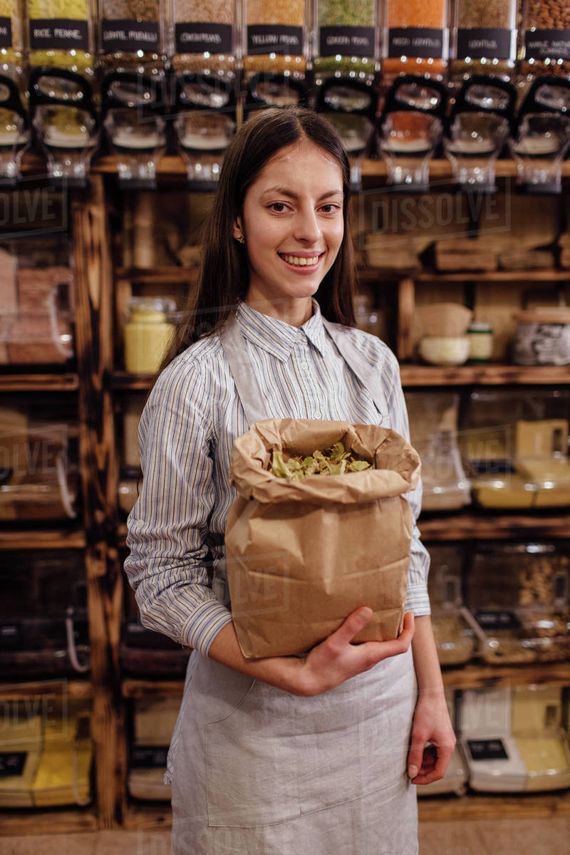 Portrait of smiling shopkeeper in package free grocery store. Cheerful ...