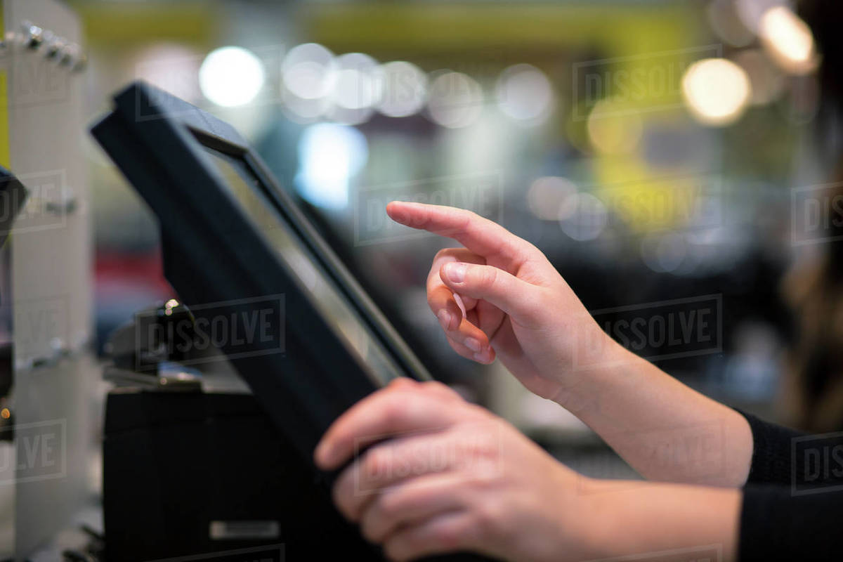 Young woman hand doing process payment on a touchscreen cash register ...