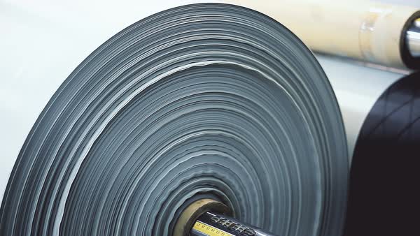 Thick plastic roll of sheet unrolling close-up. Static shot of the ...