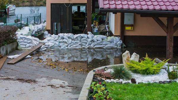 Sandbag wall around house. Protecting home against flood with white ...