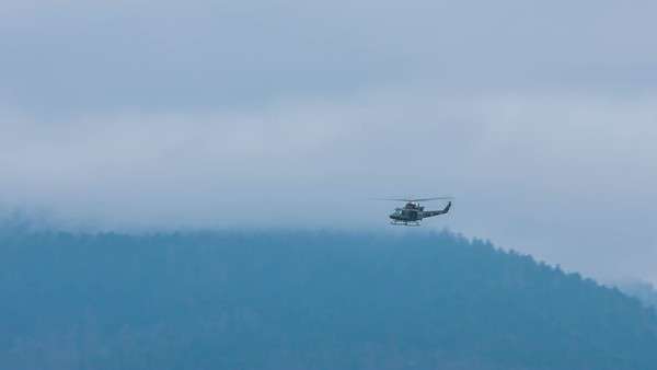 Army helicopter far away in air. Flying military helicopter over ...