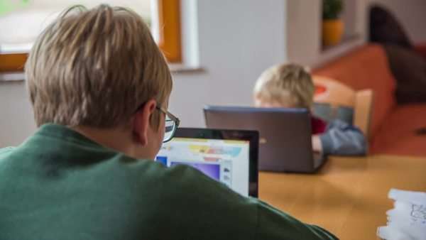 Kids playing games on computers. Behind the shoulder view of kid ...