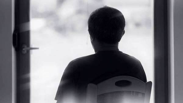 Depressed person watching through windows. Person portrait from back ...