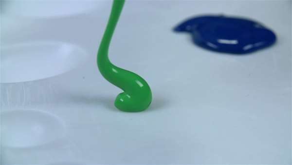 Painter adding colors to white palette and mixing them together to get ...