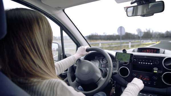 View over shoulder inside car cabin while female person driving car on ...