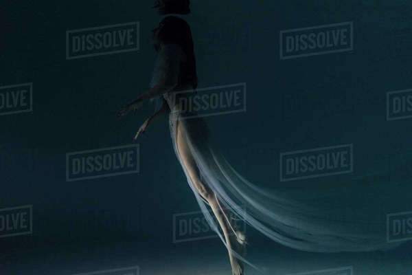 Underwater shoot of beautiful woman in white flying transparent dress ...