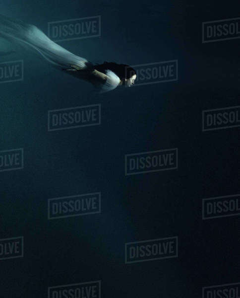 Underwater shoot of beautiful woman in white flying transparent dress ...