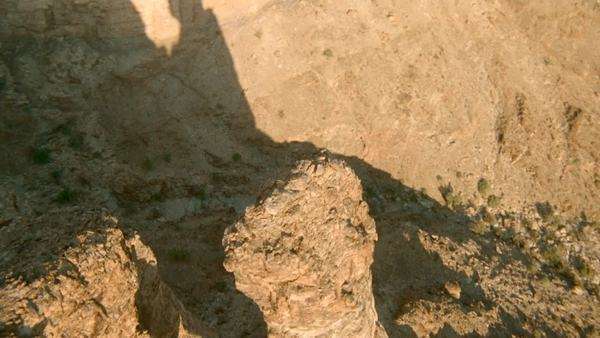 aerial close up around rock formation and rocky cliff in desert with ...