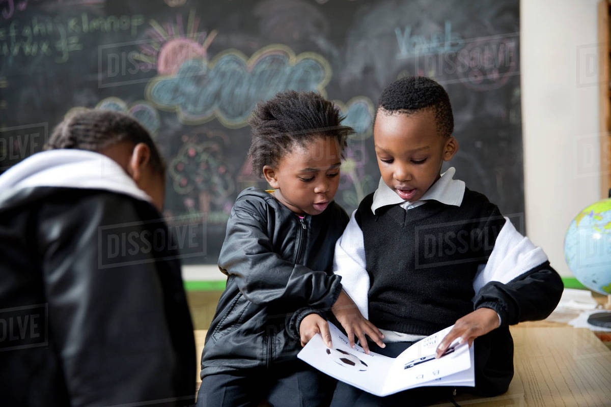 School kids reading in the classroom - Stock Photo - Dissolve