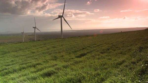 Low angled extreme long shot of wind turbines on wind farm, shadows ...