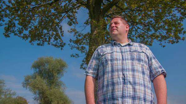 Man stand under big tree. Sliding around a man with check shirts ...