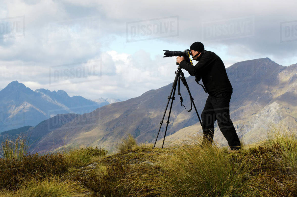 Professional on location and nature photographer (man) photographing ...