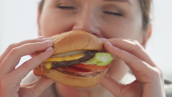 Close-up zoom funny face woman eating burger at outside vegetarian ...