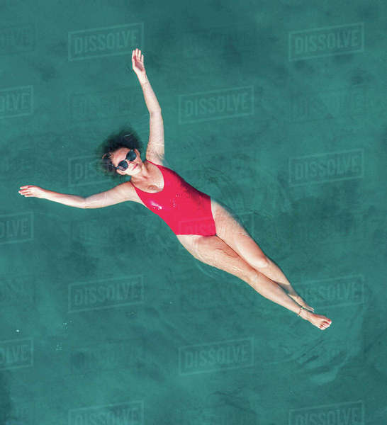 Aerial View of a Woman in Red Swimsuit Floating Serenely on the Crystal ...