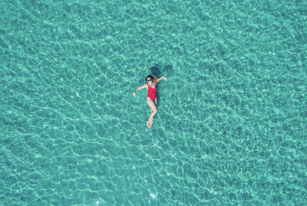 Aerial View of a Woman in Red Swimsuit Floating Serenely on the Crystal ...