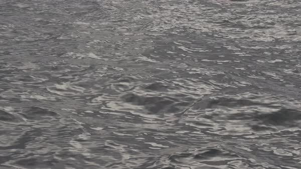 Close-up of shallow sea water surface texture, silver sea at depressive ...
