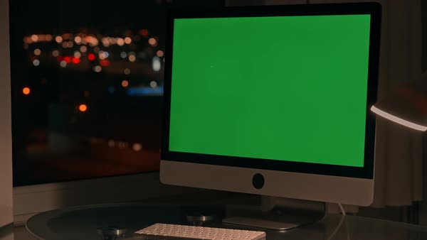 Empty workplace in office at night desk with computer green screen ...