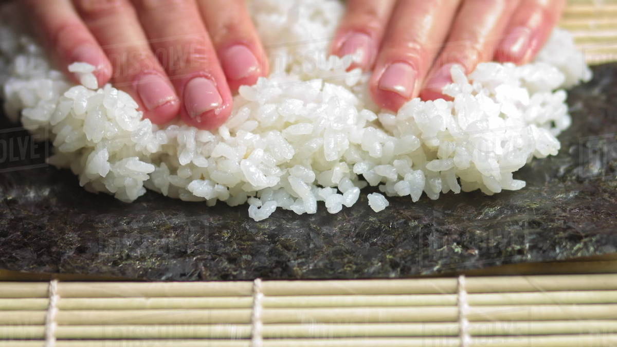 Spreading Cooked Sushi Rice On A Seaweed Wrap - Sushi Making - close up ...