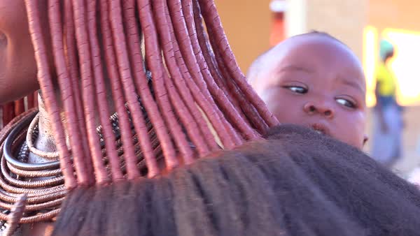 A Himba tribal woman shows off her braided, mud caked, dreadlock hair ...