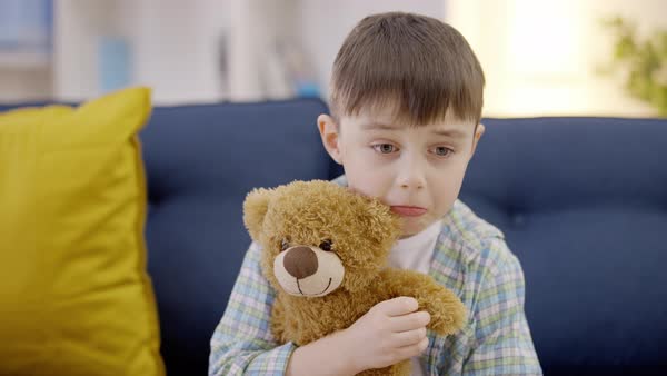 Sad child hugging teddy bear toy, negative emotions, bad memories ...
