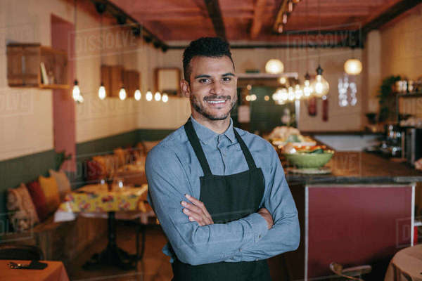 Cheerful positive handsome restaurant owner with crossed arms proud by ...