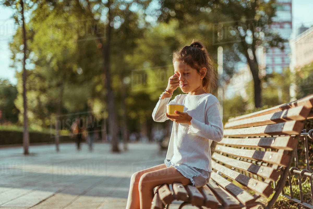 Child eating ice cream on a park bench. - Royalty-free Stock Photo ...