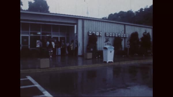 1977 - People line up in the rain to enter an army Post Exchange. A ...