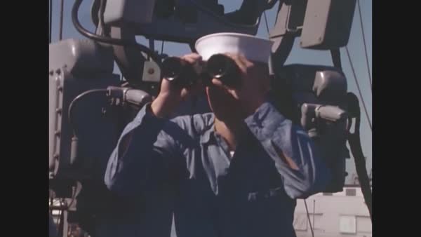 1969 - A lookout scans the sea with binoculars from the deck of the USS ...