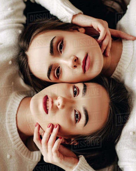 Top view of two sister twins with natural beauty lying head to head at ...