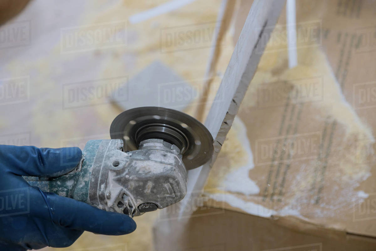 Construction trimming tiles worker cutting a tile using grinder ...