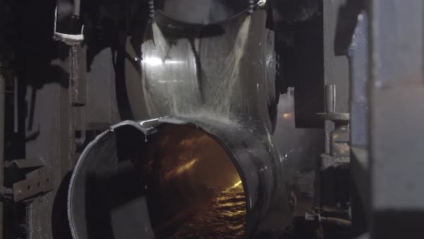 Tube rolling process at manufacturing plant. Closeup of production ...