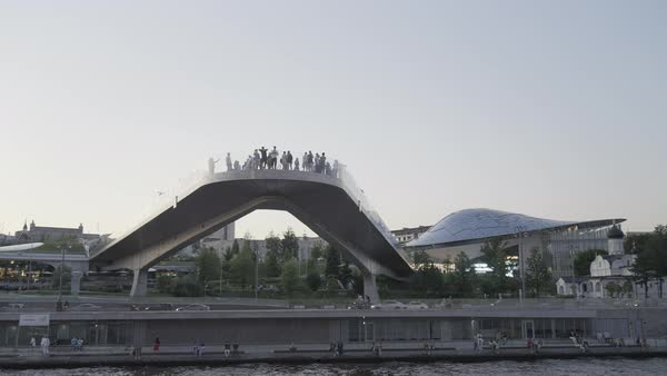 Beautiful bending bridge above river on a blue sky background. Action ...