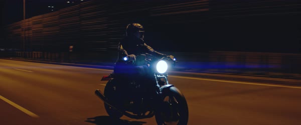 TRACKING Shot of a biker riding his custom built cafe racer motorcycle ...