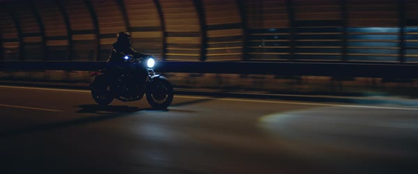 TRACKING Shot of a biker riding his custom built cafe racer motorcycle ...