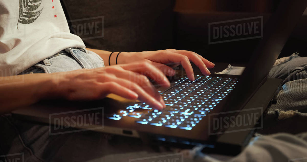 Close up woman hands working typing on keyboard laptop computer at dark ...